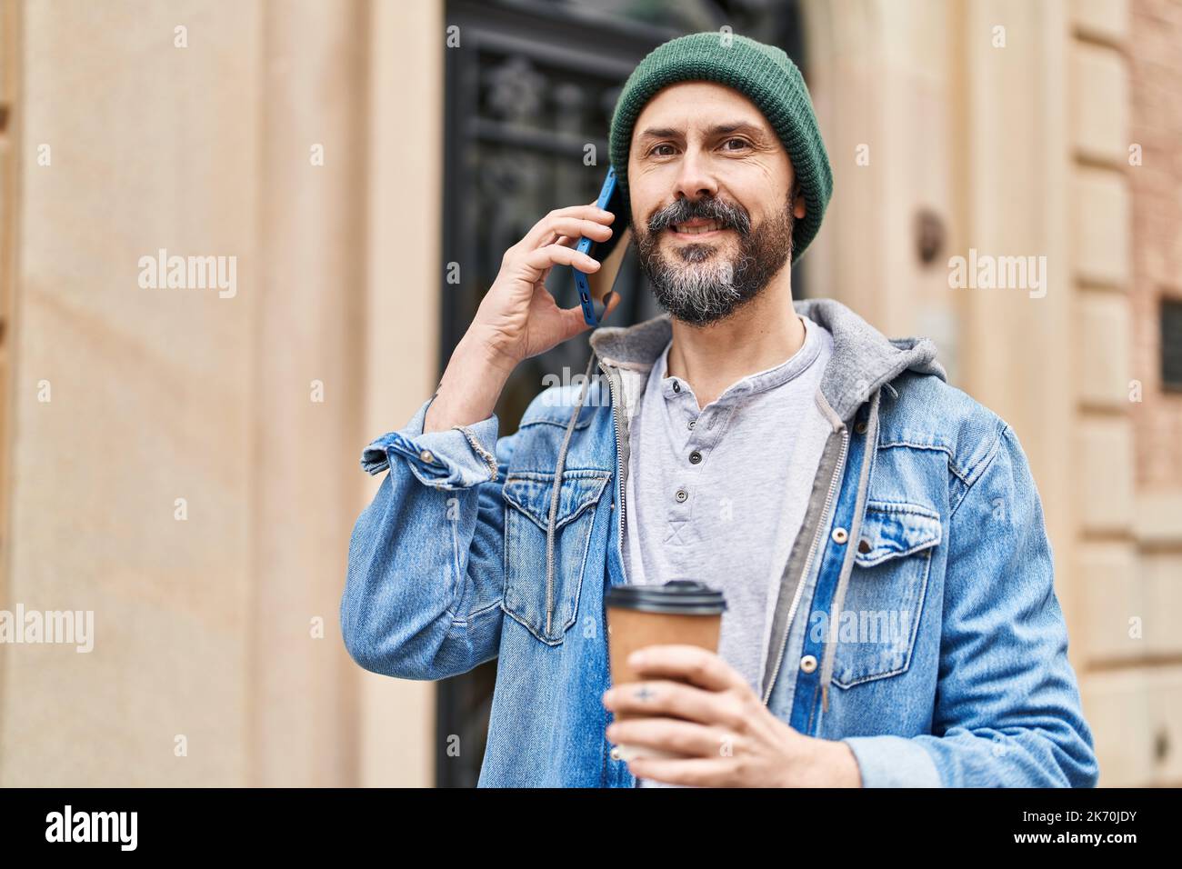 Young bald man talking on smartphone drinking coffee at street Stock ...