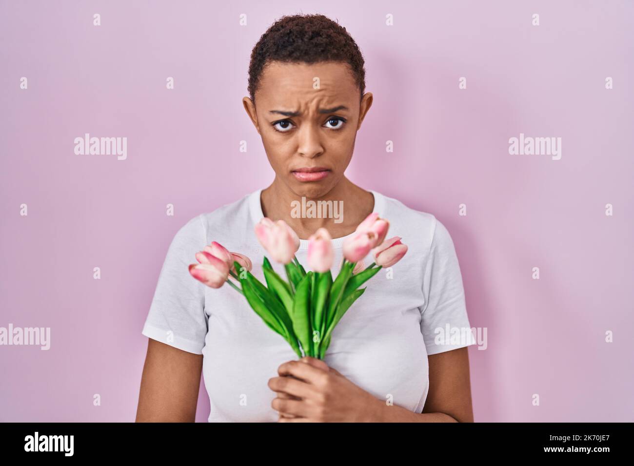 Beautiful african american woman holding bouquet of pink tulips flowers ...