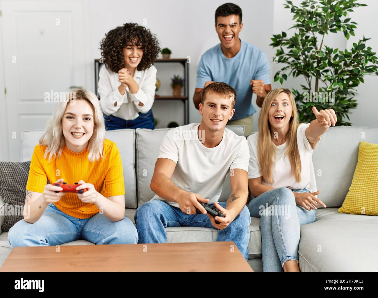 Group of young friends smiling happy playing video game at home Stock ...