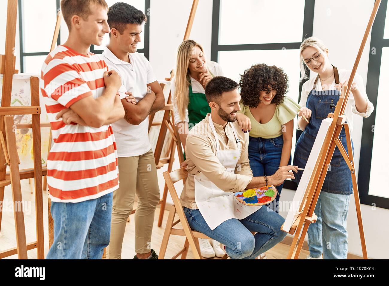 Group of people smiling happy and looking draw of partner at art studio ...