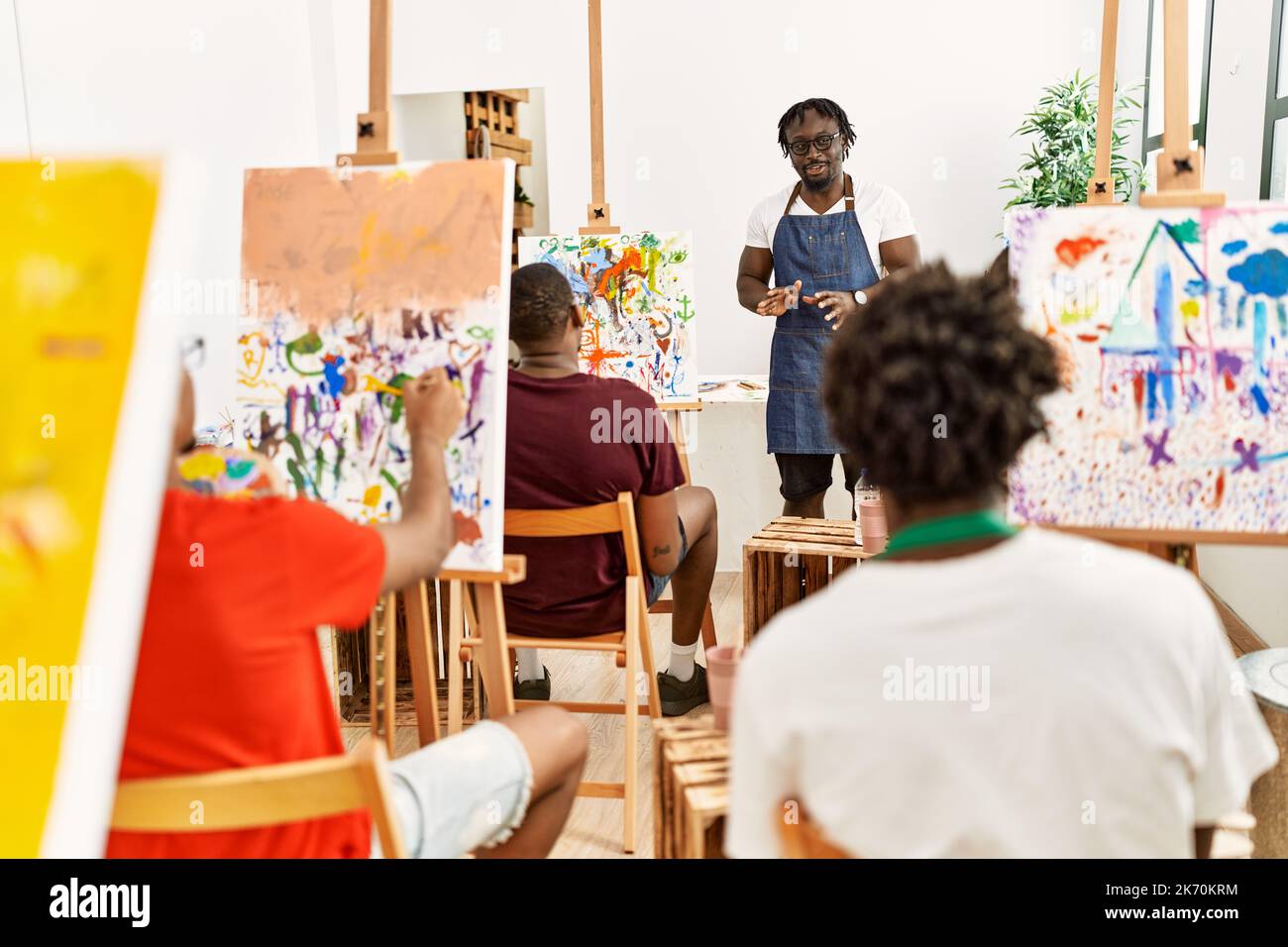 Group of young african american artist students drawing in paint class ...