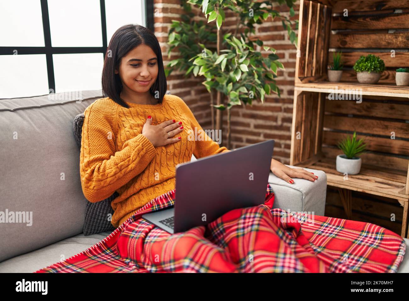 Young latin woman having video call using deaf sign language at home ...