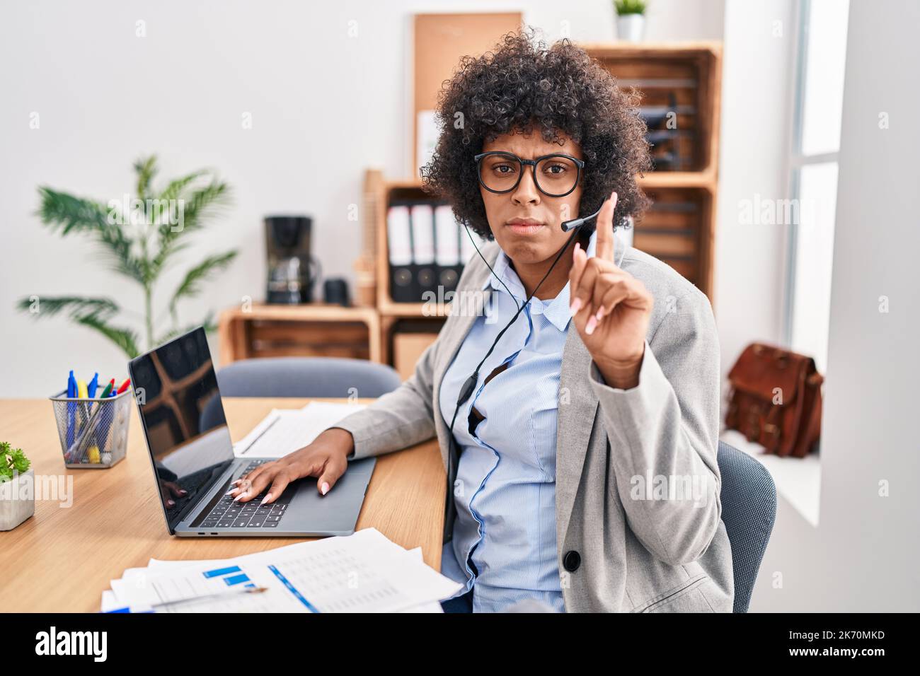 Black woman with curly hair wearing call center agent headset at the ...