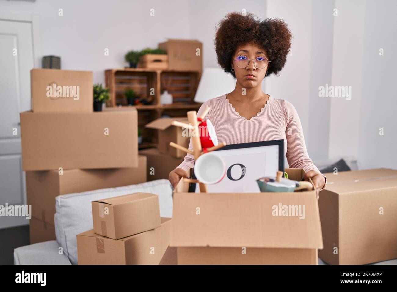 Young african american woman moving to a new home depressed and worry ...