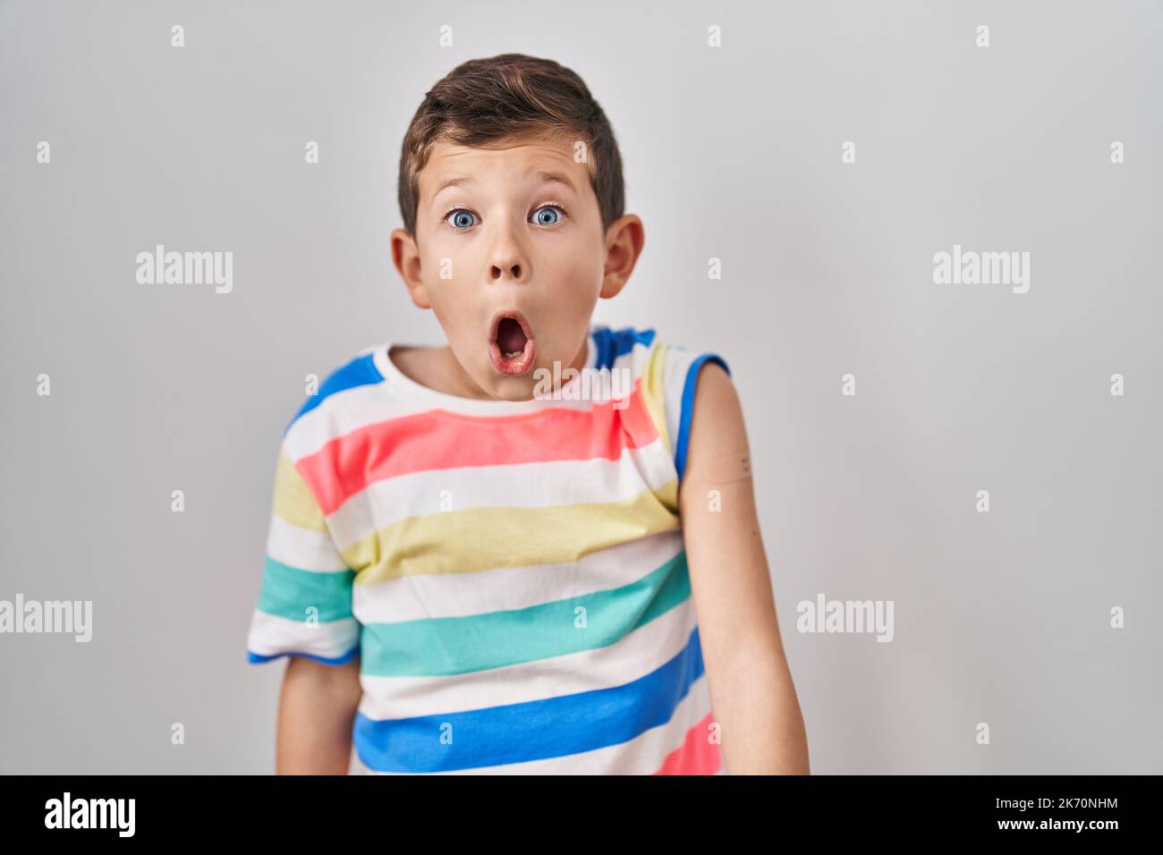 Young caucasian kid getting vaccine showing arm with band aid scared ...