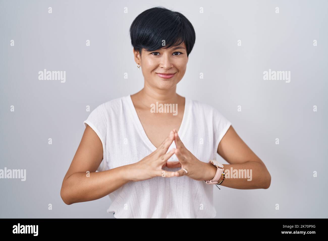 Young asian woman with short hair standing over isolated background ...