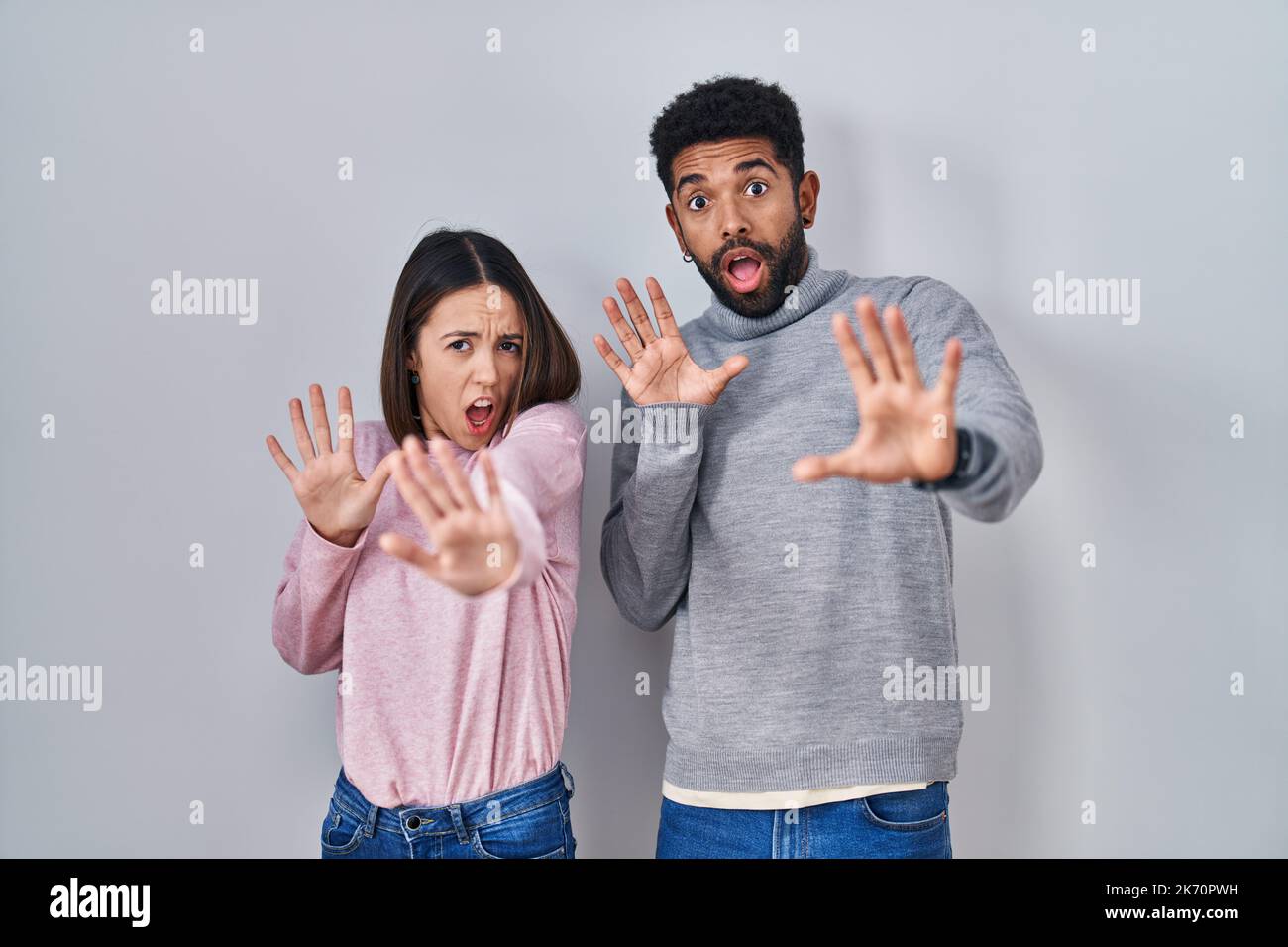 Young hispanic couple standing together afraid and terrified with fear ...