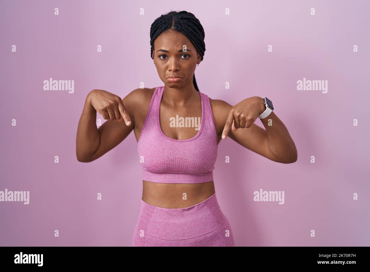 African american woman with braids wearing sportswear over pink ...