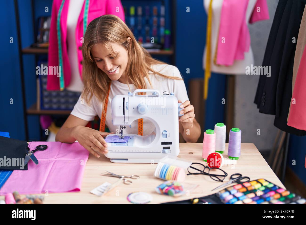 Young blonde girl tailor smiling confident using sewing machine at sewing studio Stock Photo - Alamy