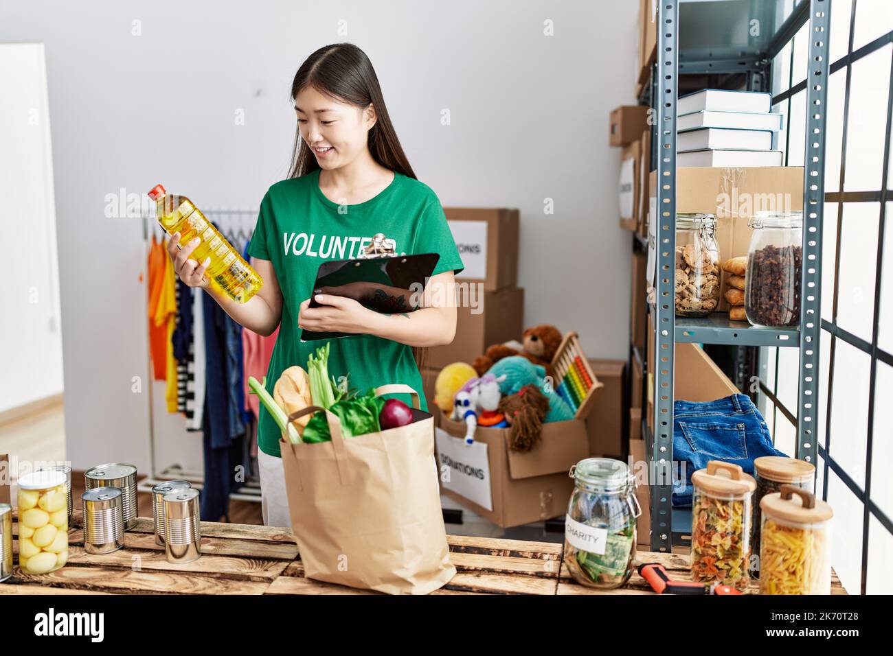 Young asian woman checking donated food at donations stand Stock Photo ...