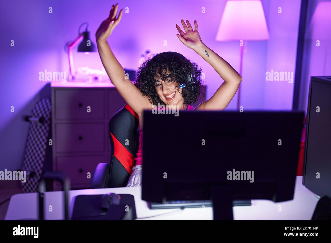 Young middle eastern woman streamer playing video game dancing at ...