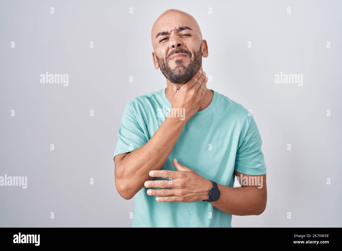Middle age bald man standing over white background touching painful ...