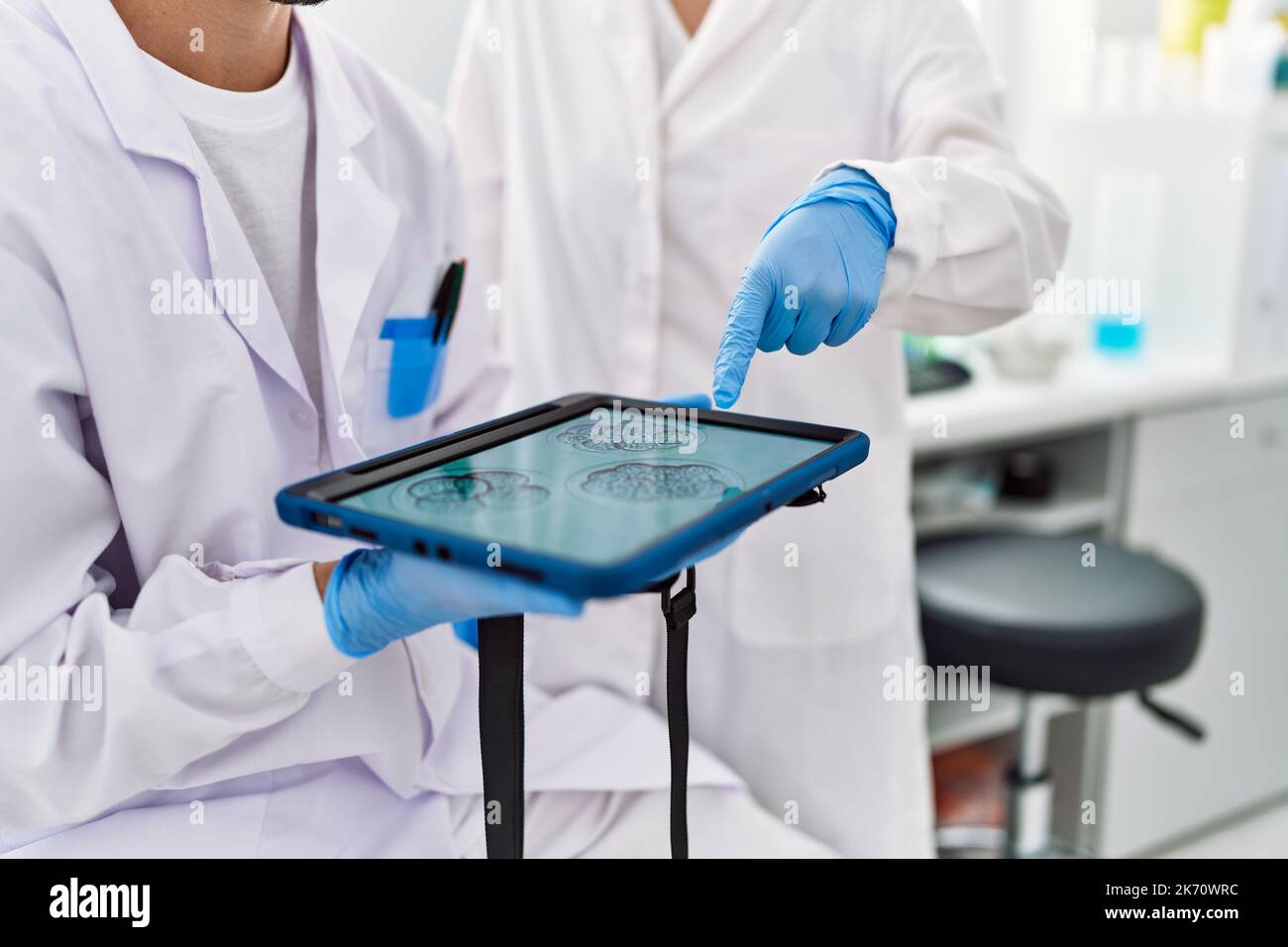 Man and woman partners wearing scientist uniform pointing with finger ...