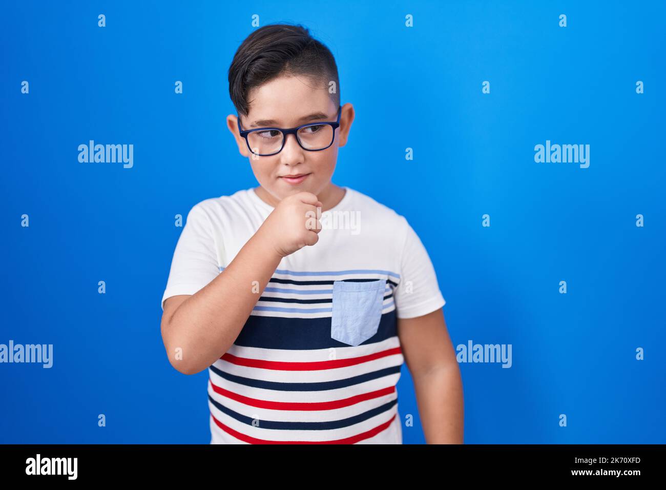 Young hispanic kid standing over blue background feeling unwell and ...