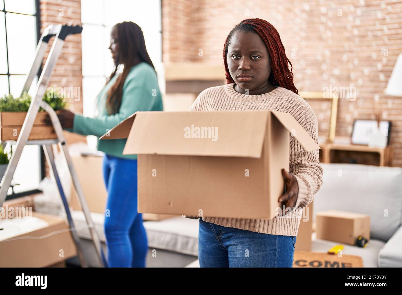 Two african women moving to a new home depressed and worry for distress ...