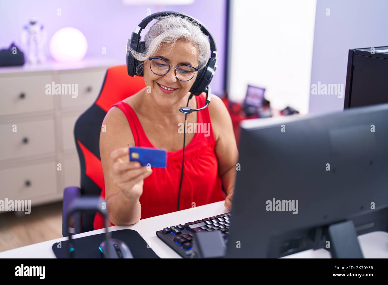 Middle age grey-haired woman streamer smiling confident using credit ...