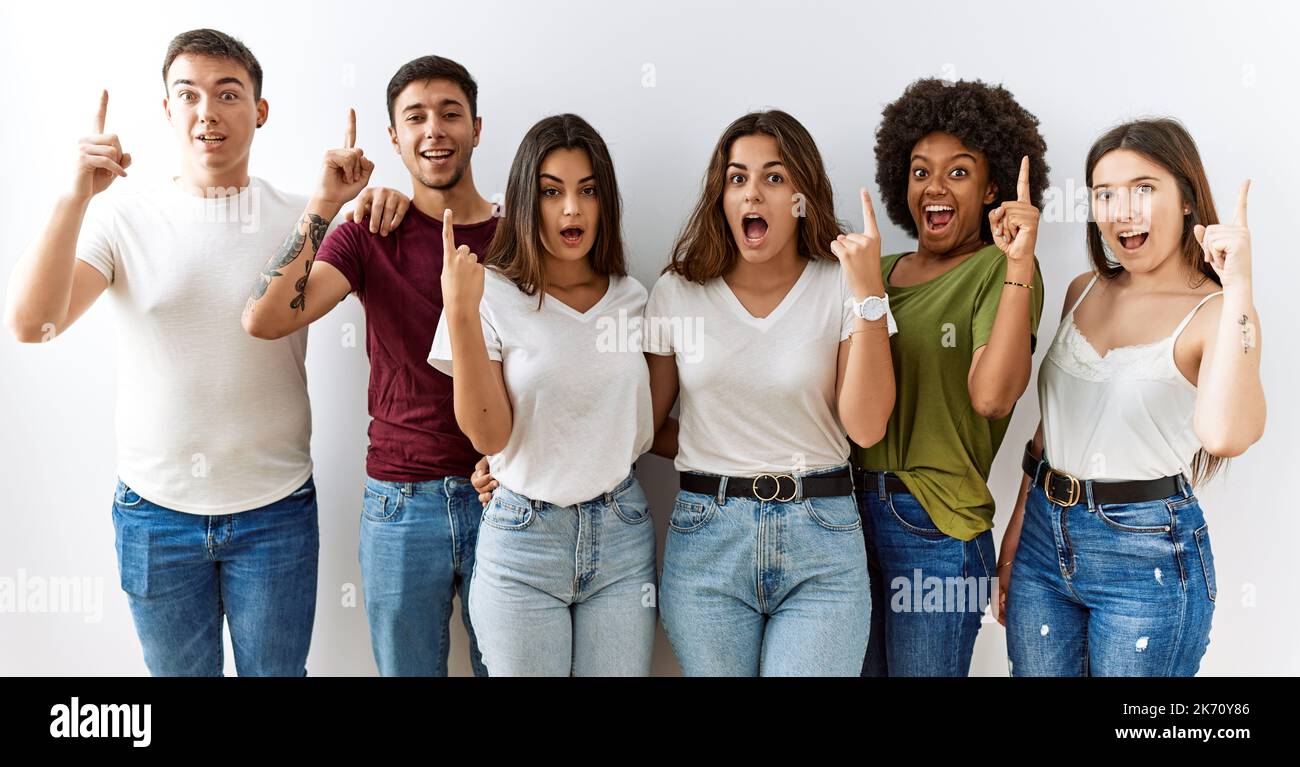 Group of young friends standing together over isolated background ...