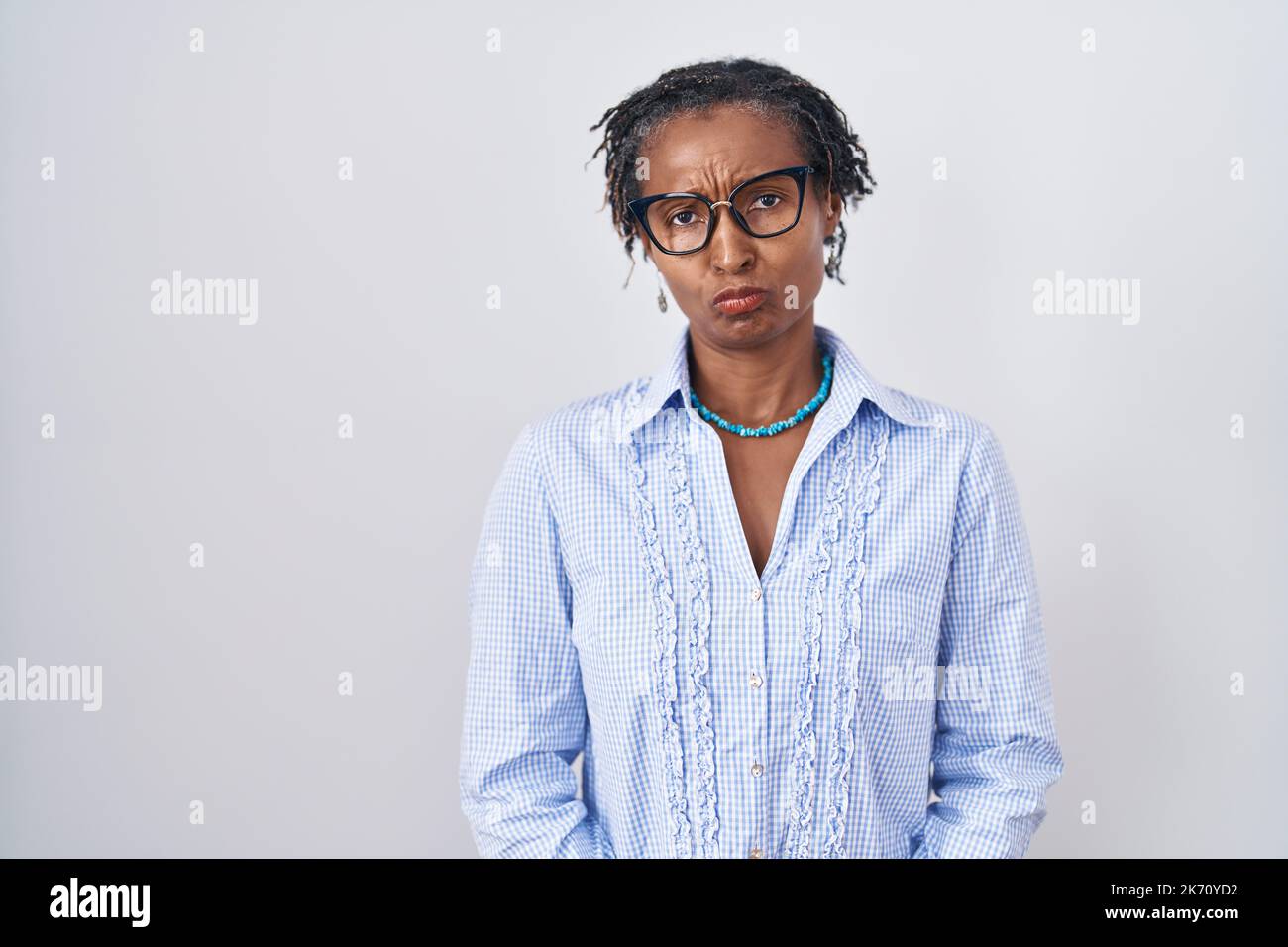 African woman with dreadlocks standing over white background wearing ...