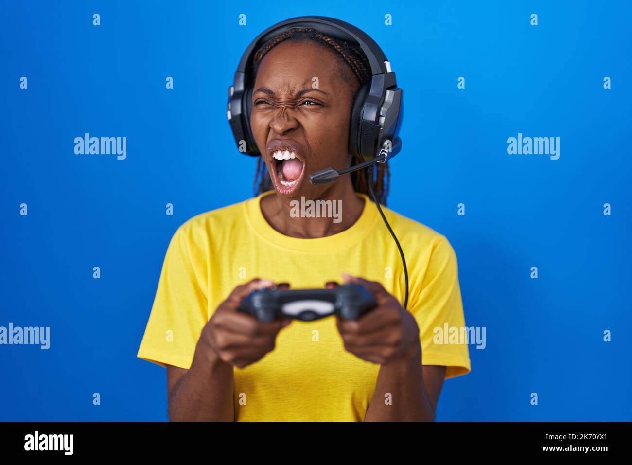 African american woman playing video games angry and mad screaming ...