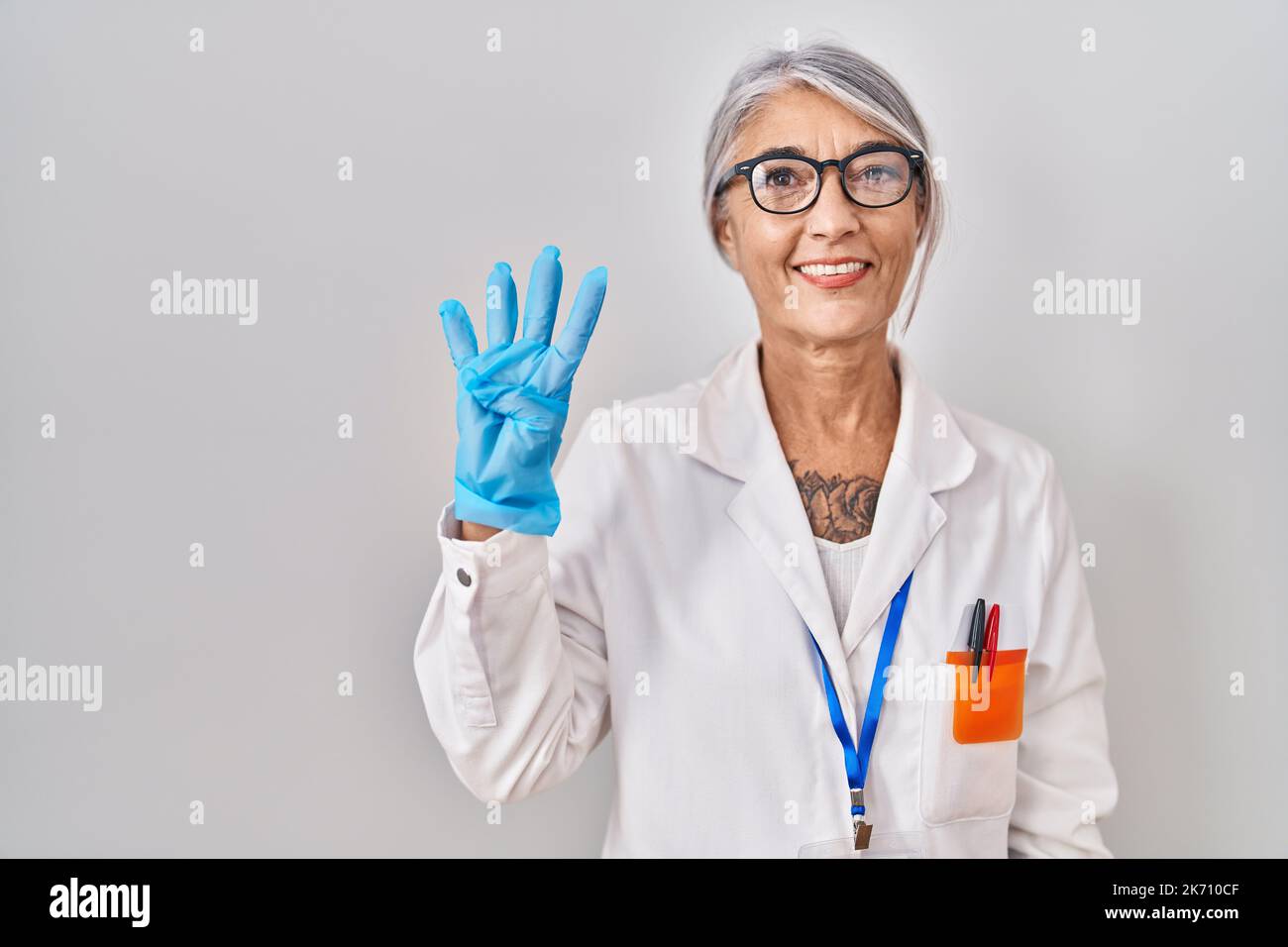 Middle age woman with grey hair wearing scientist robe showing and ...