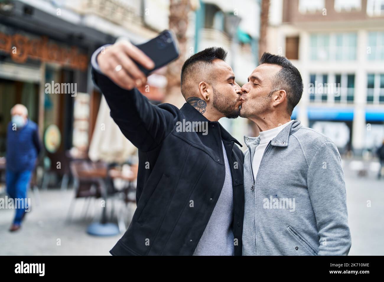 Two men couple make selfie by smartphone kissing at coffee shop terrace Stock Photo - Alamy