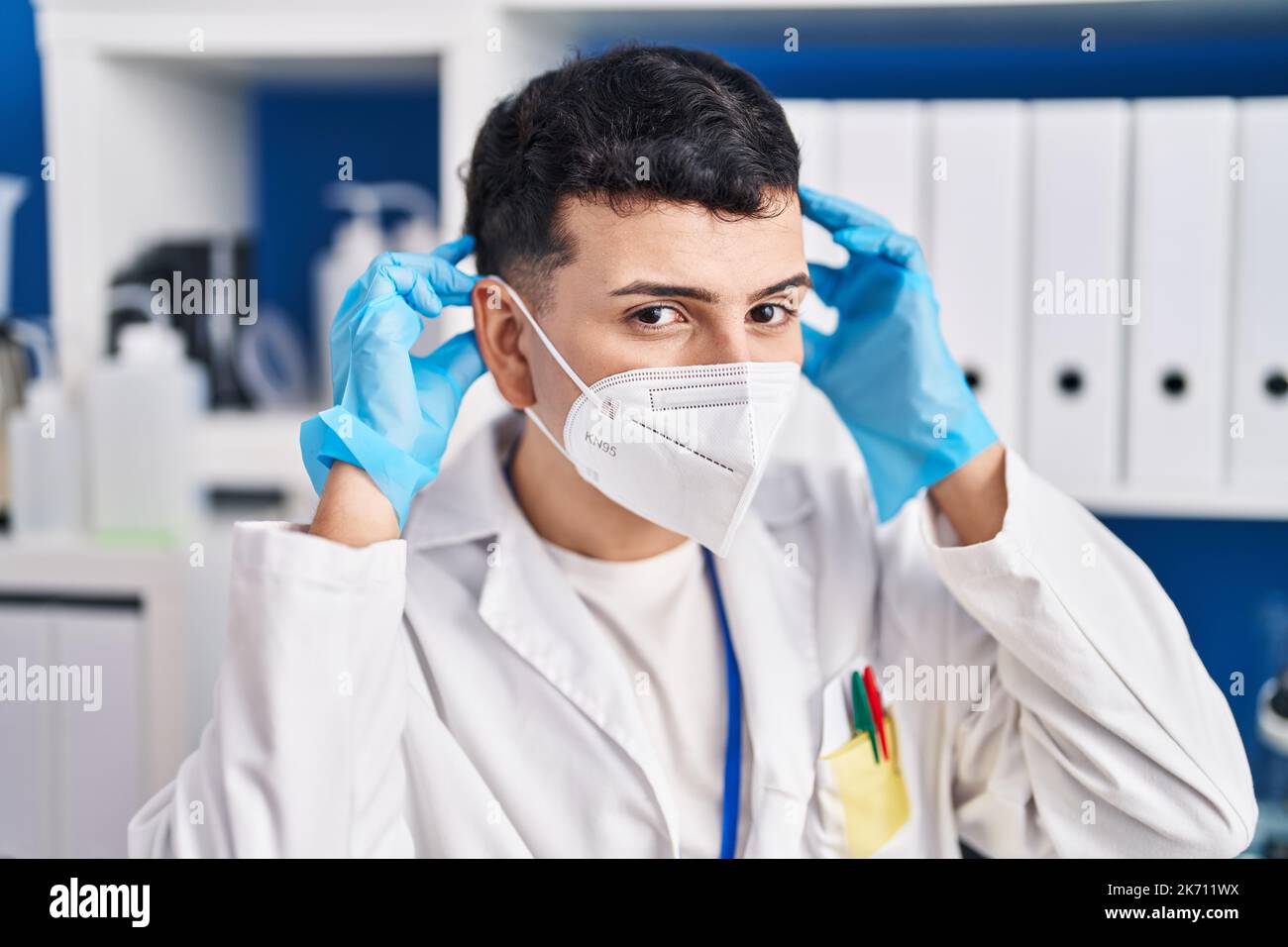 Young non binary man scientist wearing medical mask at laboratory Stock ...