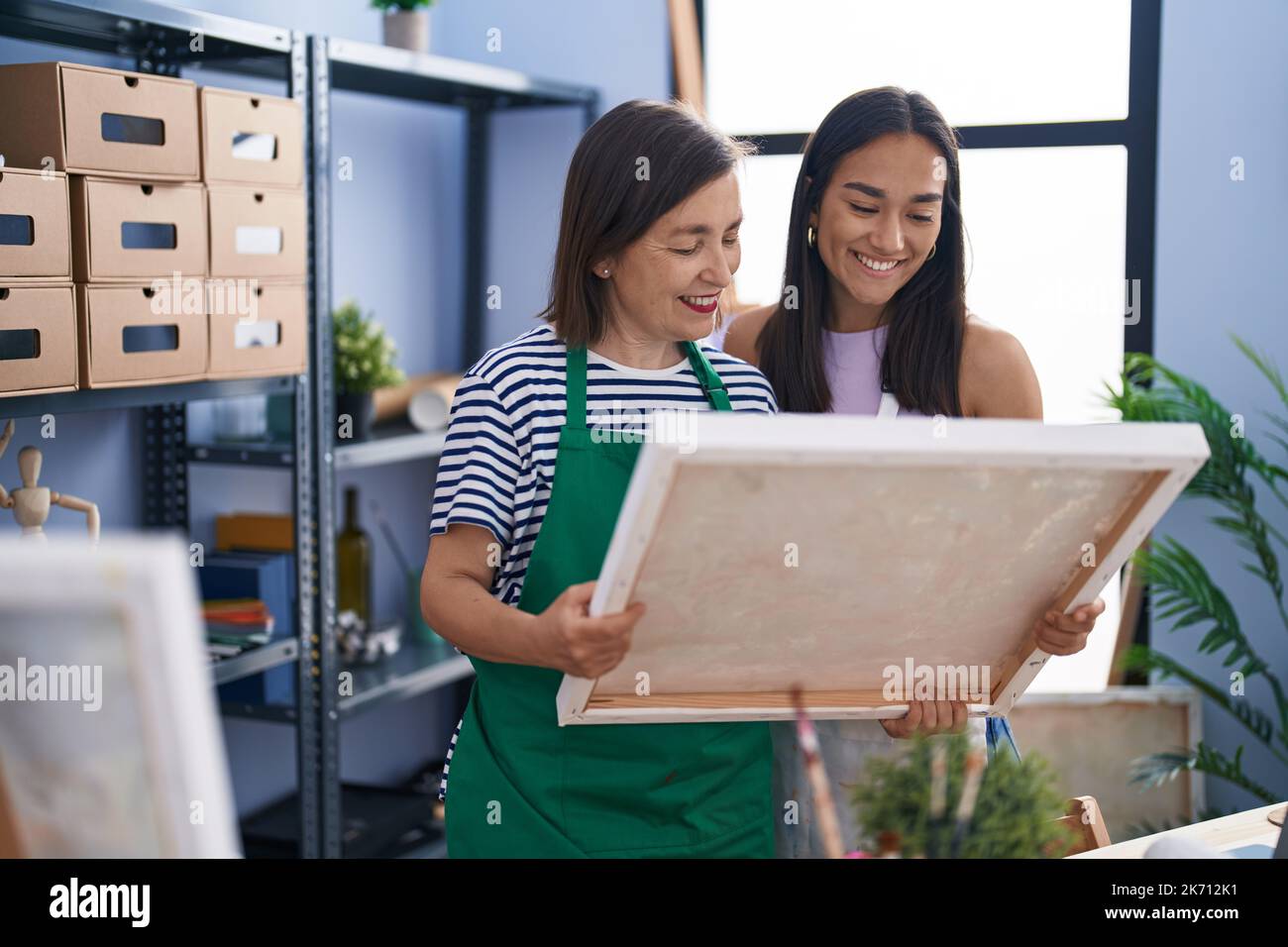 Two women artists standing together looking draw at art studio Stock ...