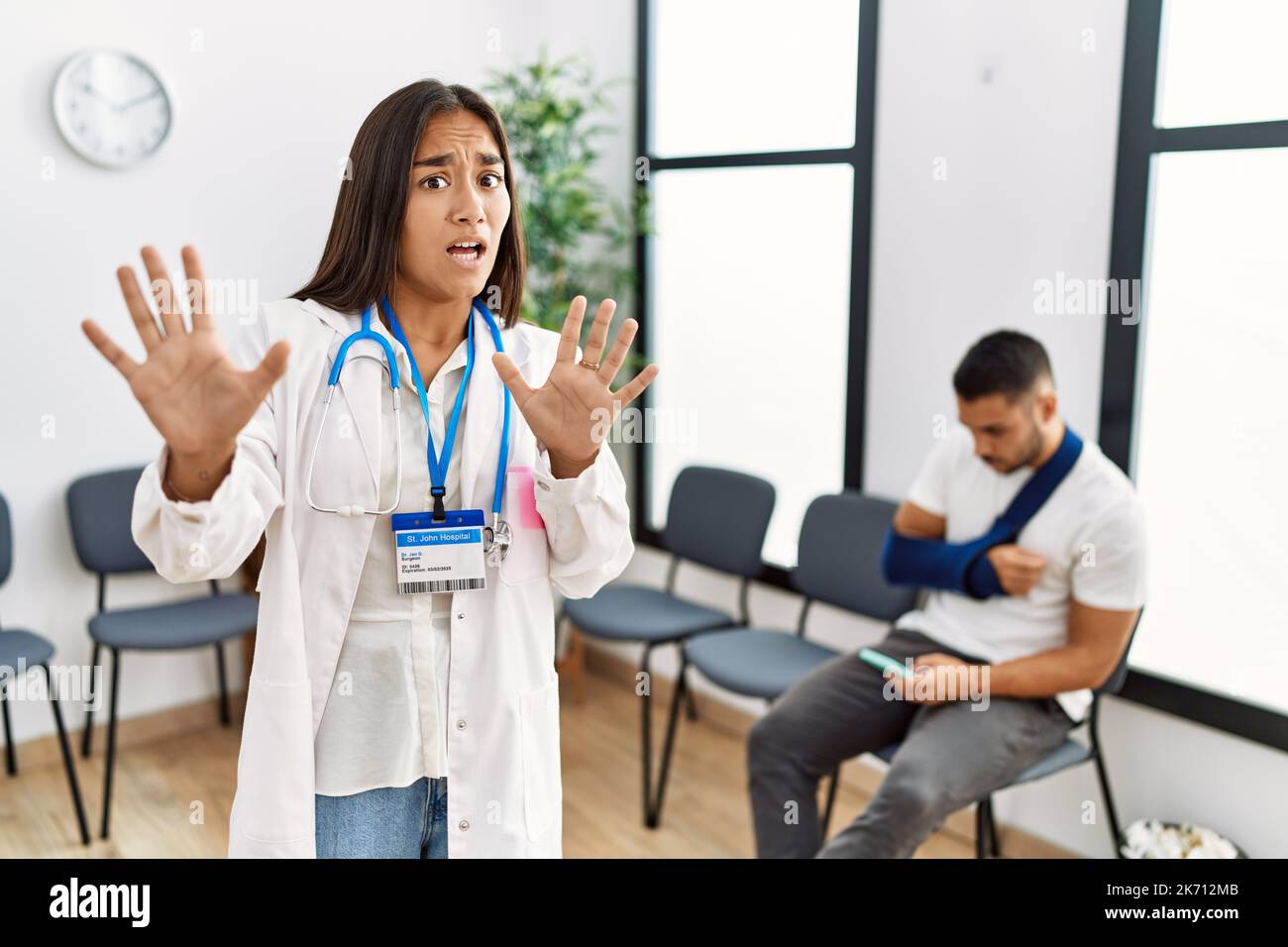 Young asian doctor woman at waiting room with a man with a broken arm ...