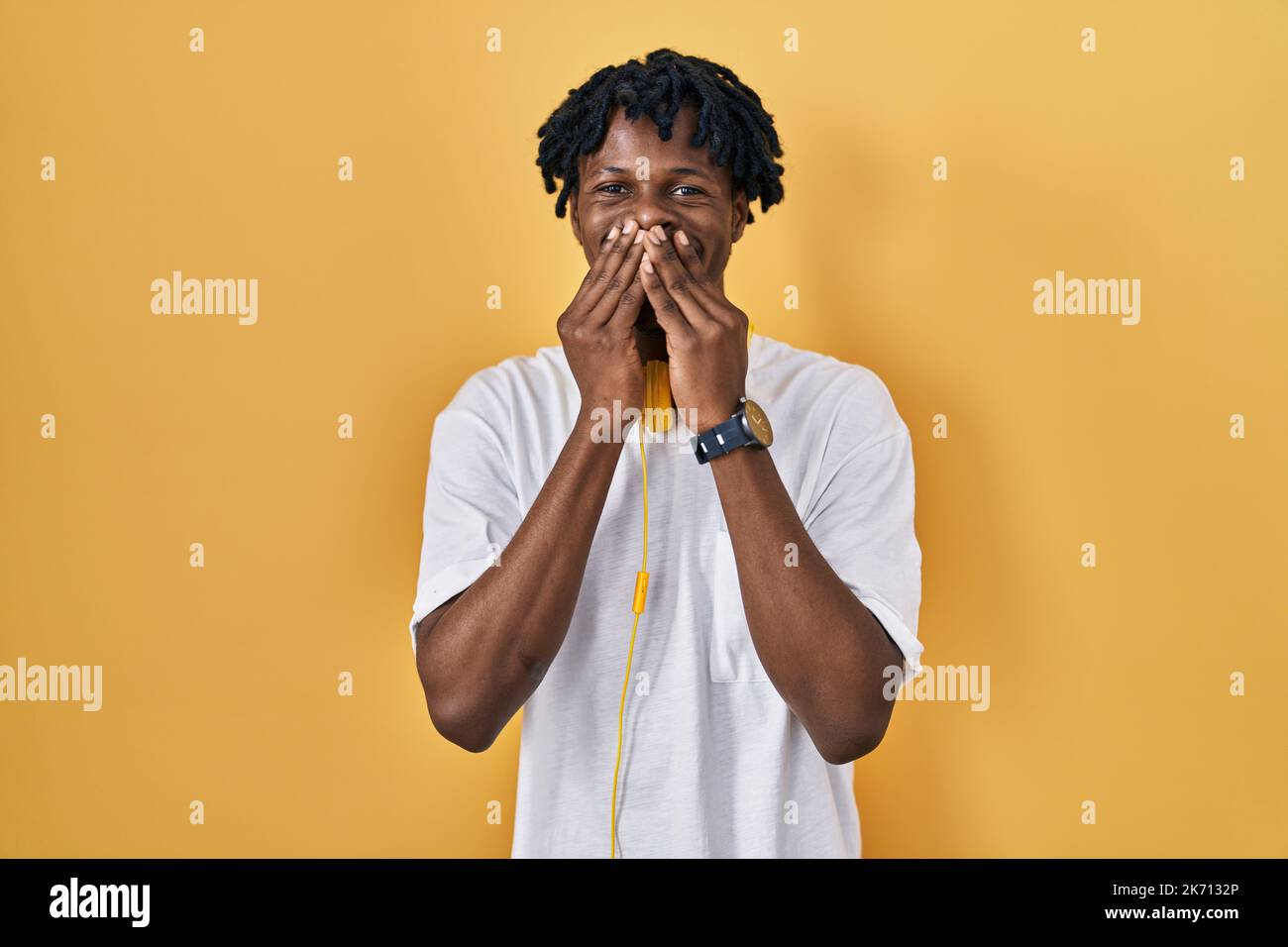Young african man with dreadlocks standing over yellow background ...