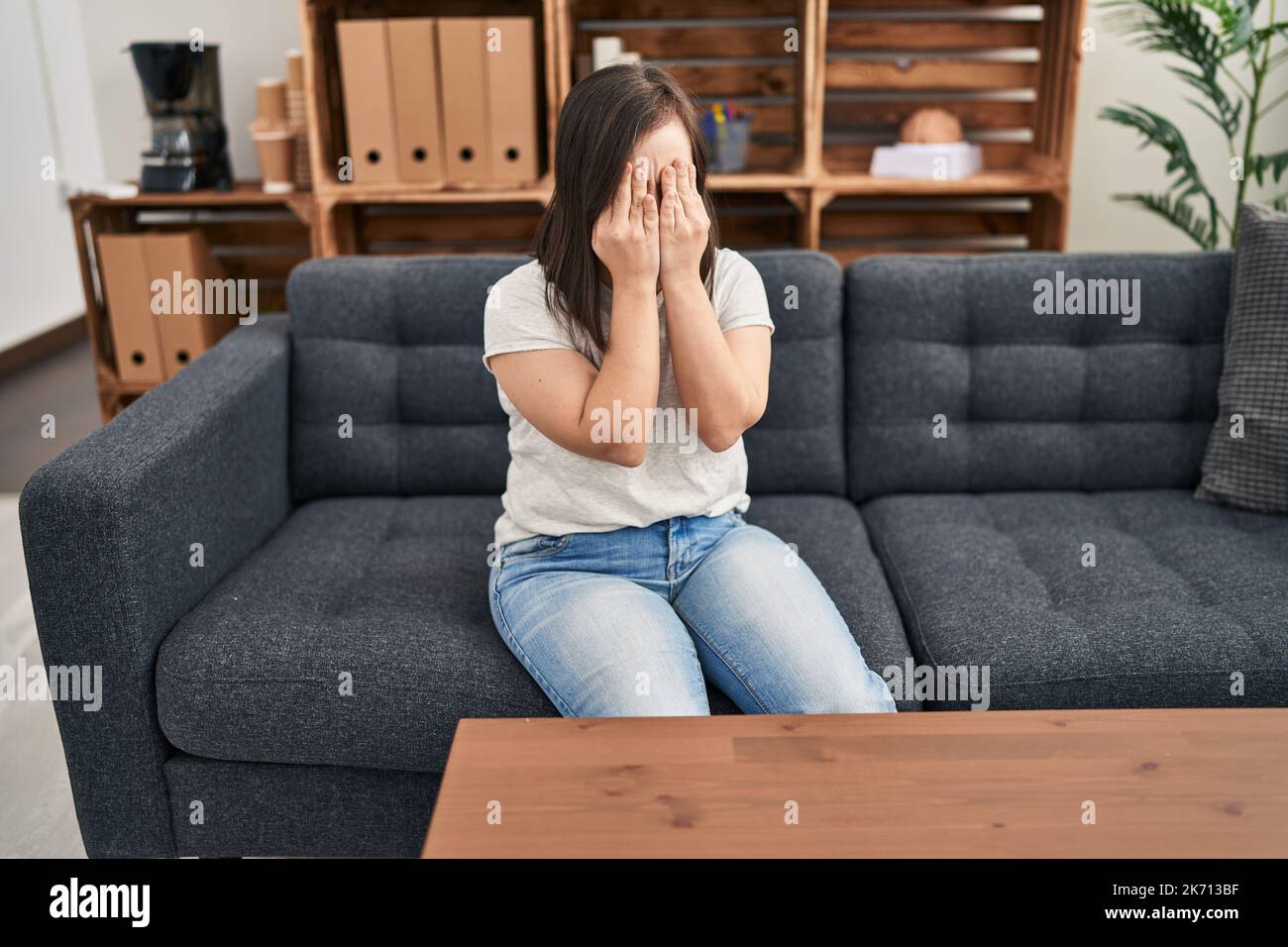Down syndrome woman patient crying having psychology session at clinic ...