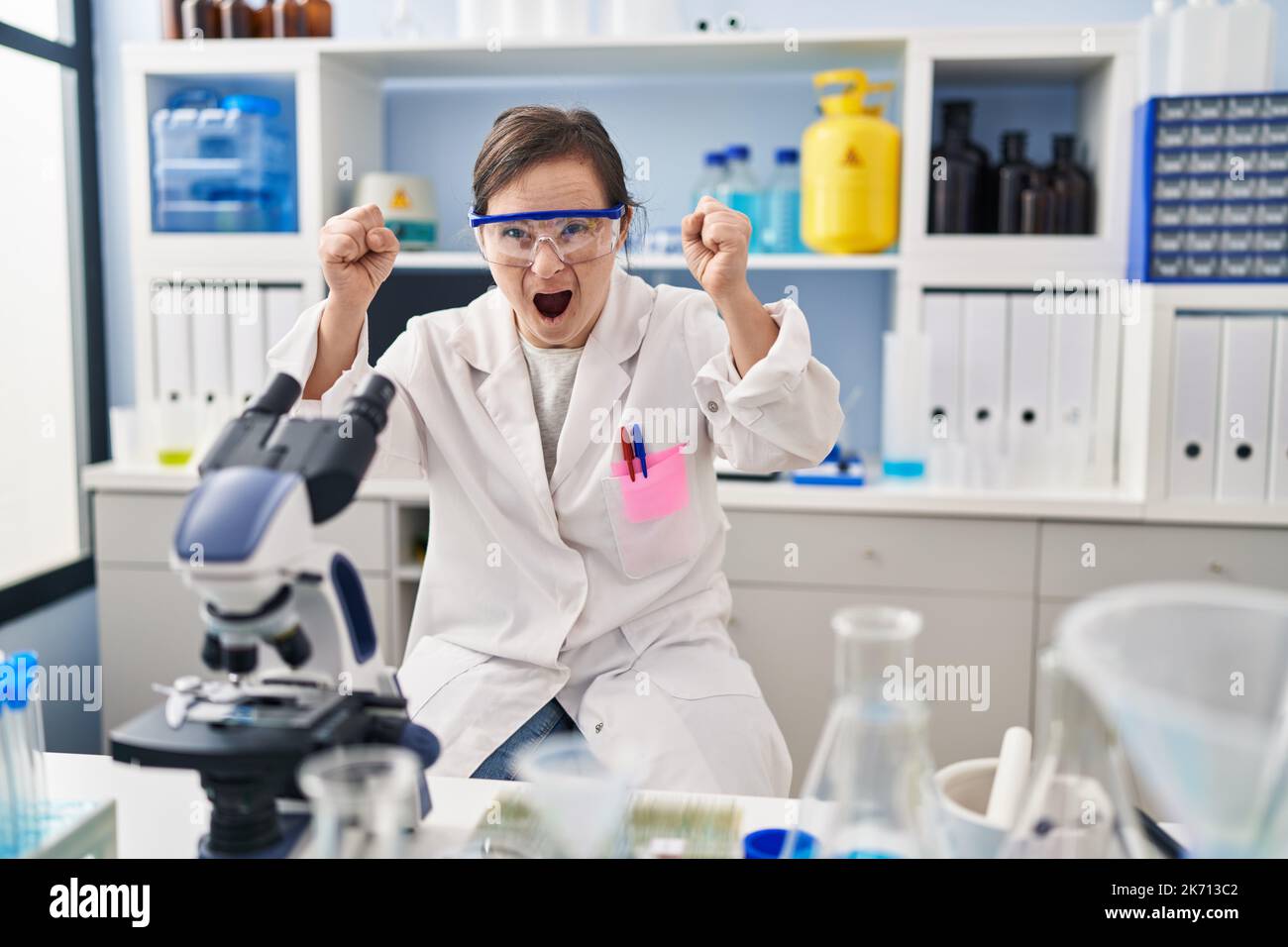 Hispanic girl with down syndrome working at scientist laboratory angry ...