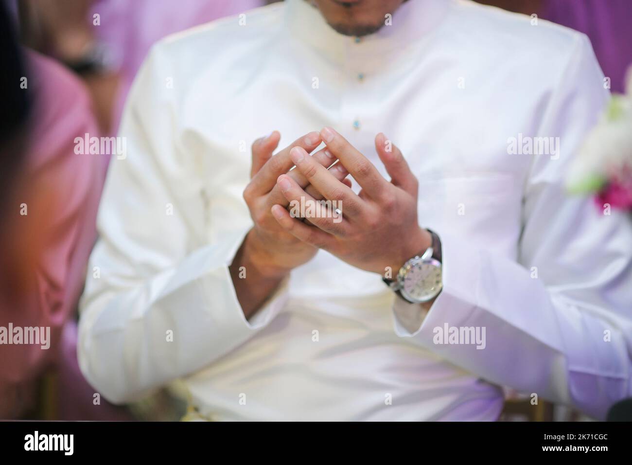 GROOM PUT HIS HAND TO PRAY DOA Stock Photo - Alamy