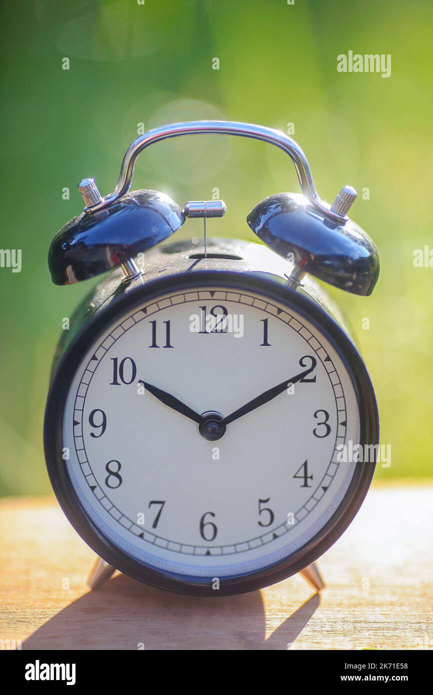 Alarm clock and green blur background Stock Photo - Alamy
