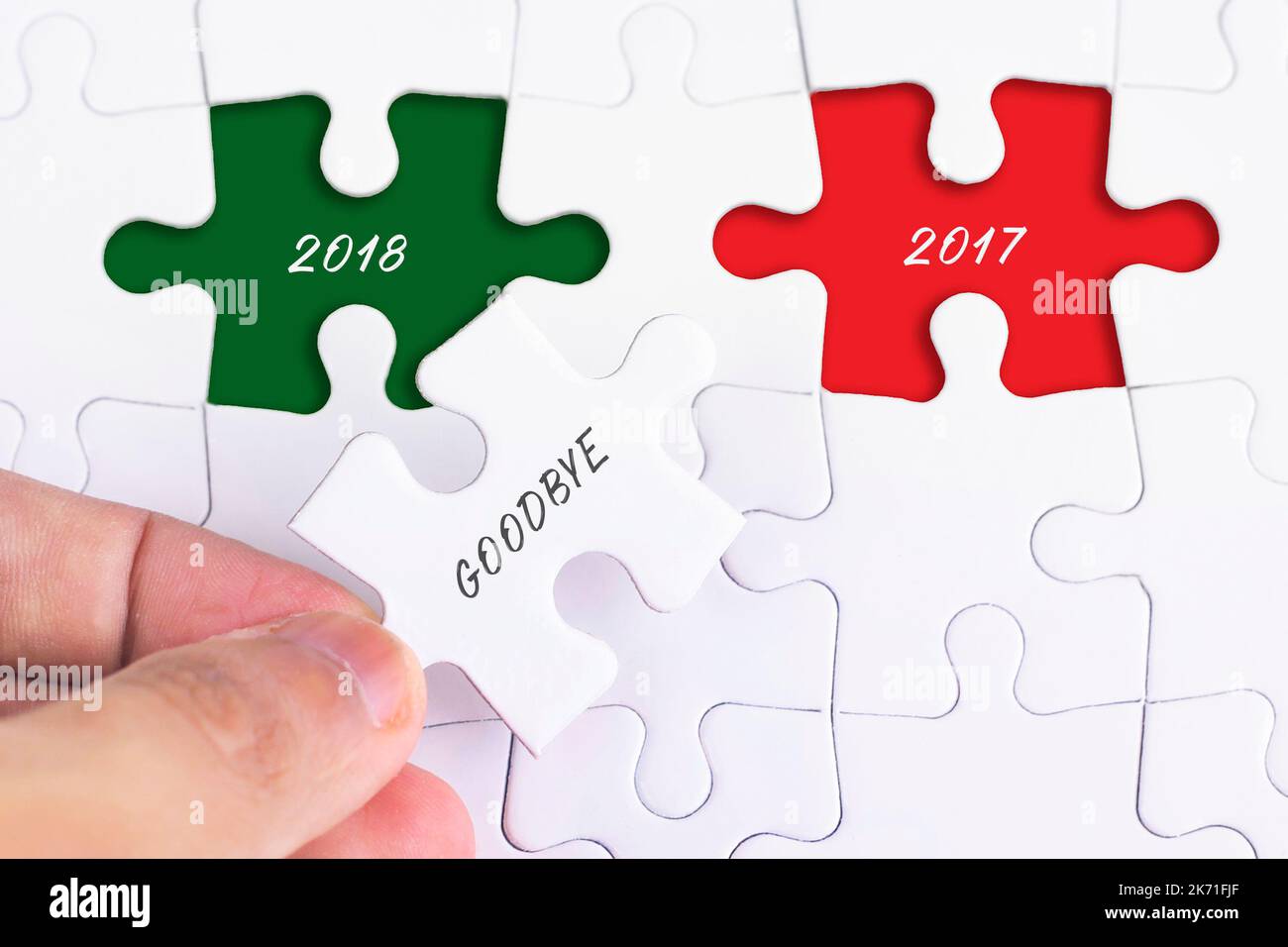 Business Concept - Female hand and missing puzzle with GOODBYE 2O17 ...