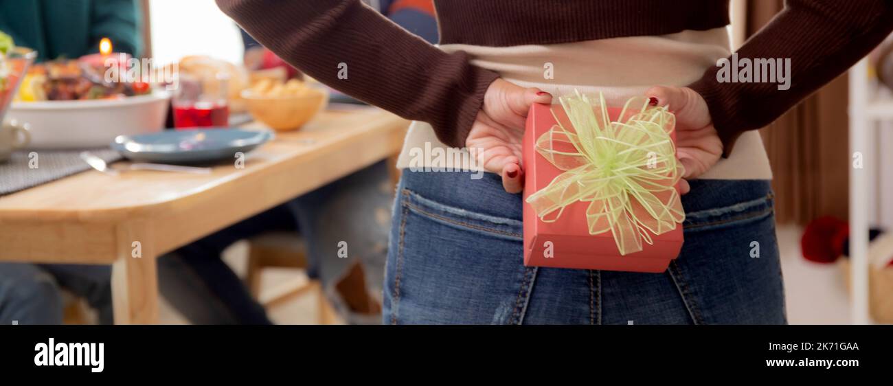 Happy family with mother giving gift box with daughter during dinner at ...