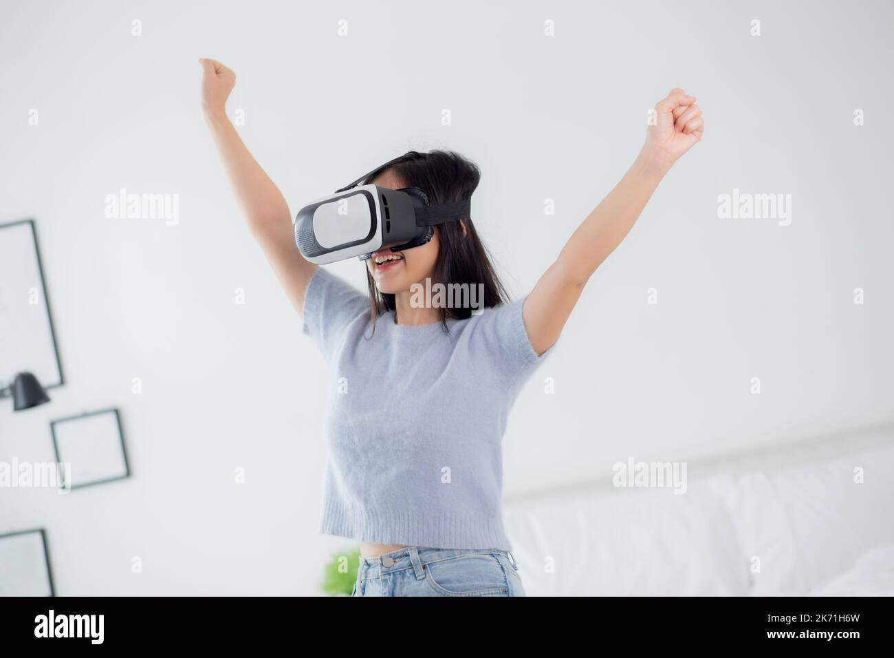 Young asian woman wearing vr headset playing game with excited in the ...