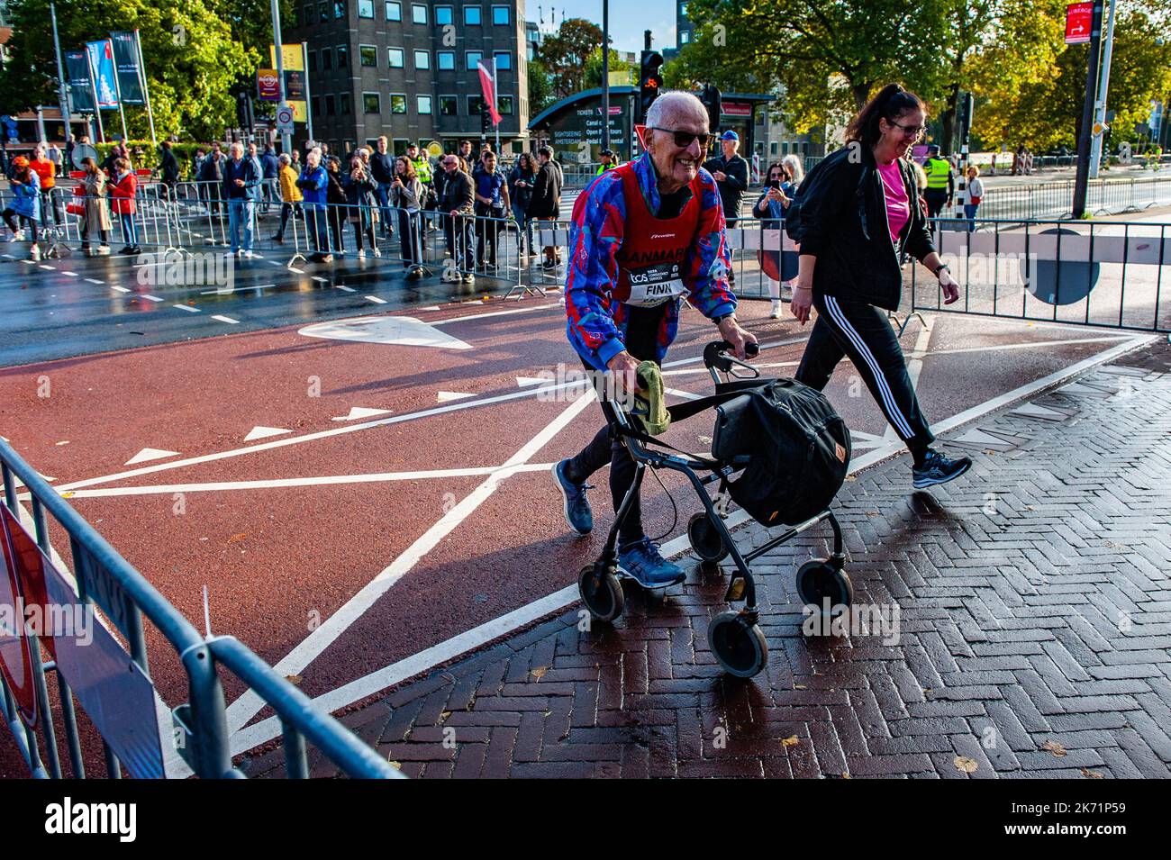 An old man participates in the marathon with the help of a walker. More ...