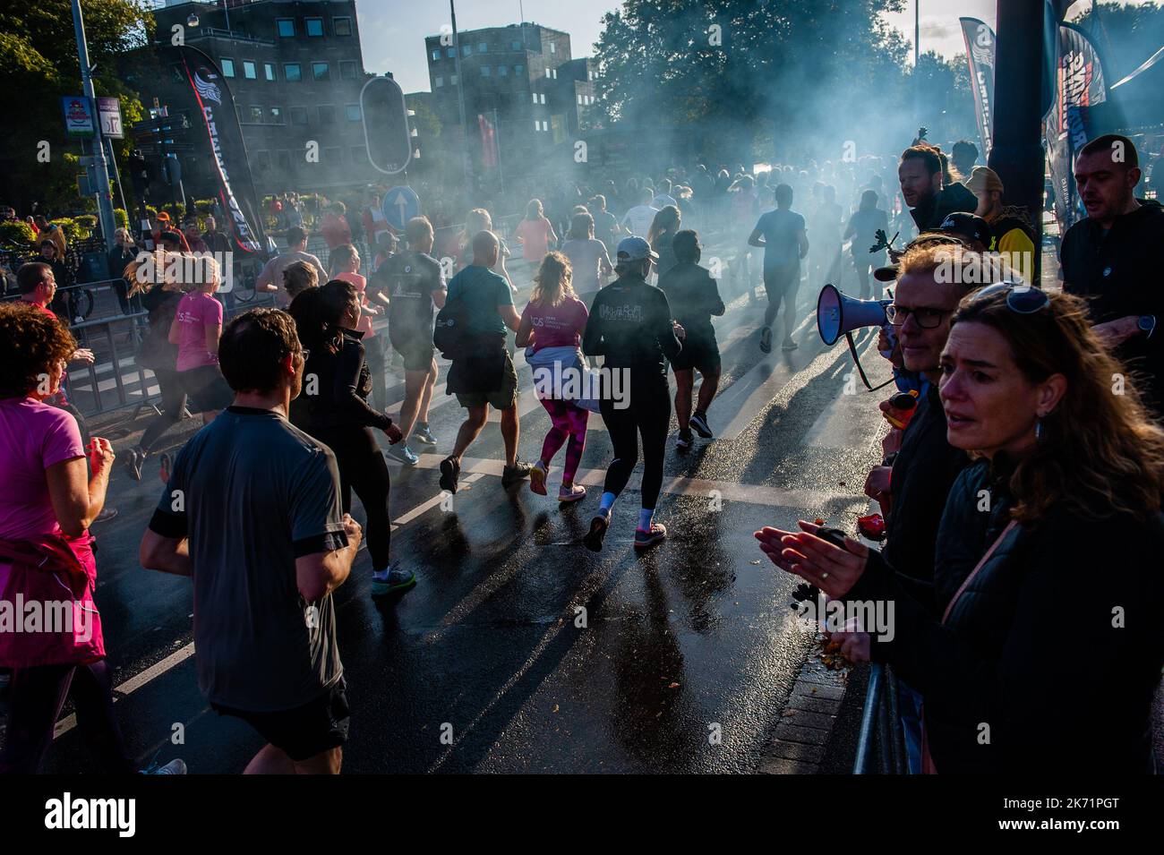 Participants are seen running crossing a smoke bomb. More than 18,000 ...