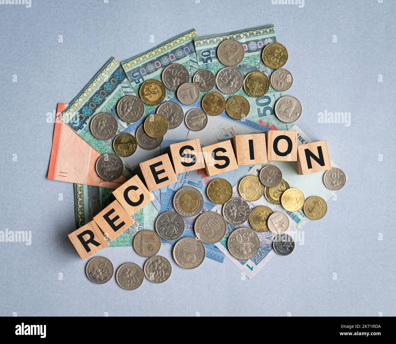 Recession, word on wood block, and paper currency and coins at the ...
