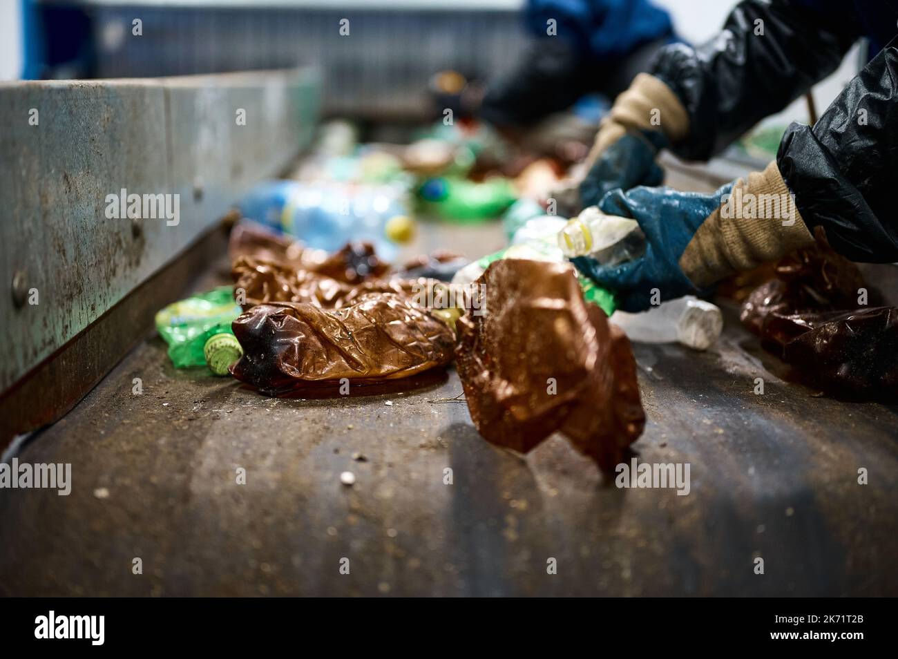 Worker sorts trash on conveyor belt at waste recycling plant Stock Photo - Alamy