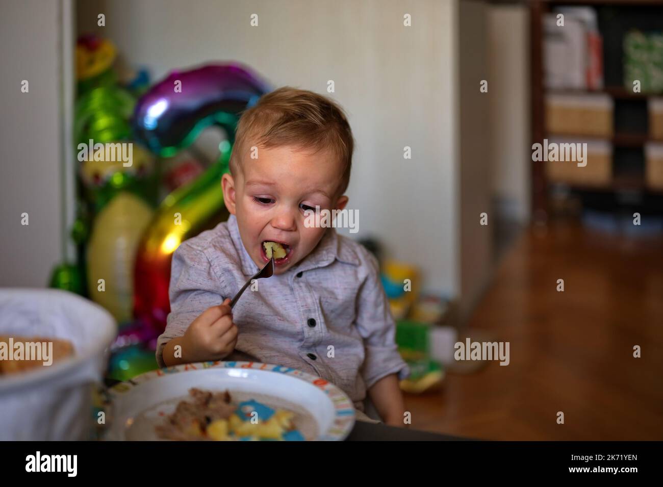Cute little toddler using fork and eating snack Stock Photo - Alamy