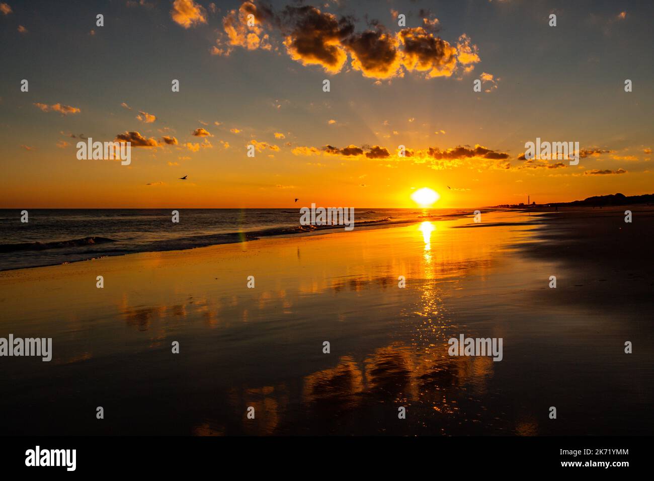 Incredible sunset on the beach. Reflections of the golden lights in the ...