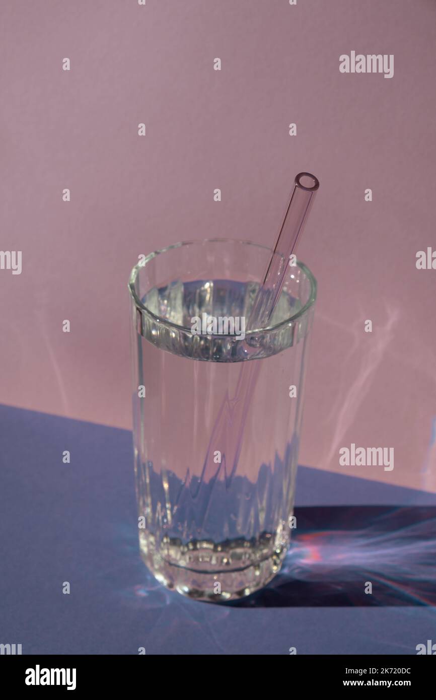 Reusable glass Straws in Glass with water on purple violet background ...