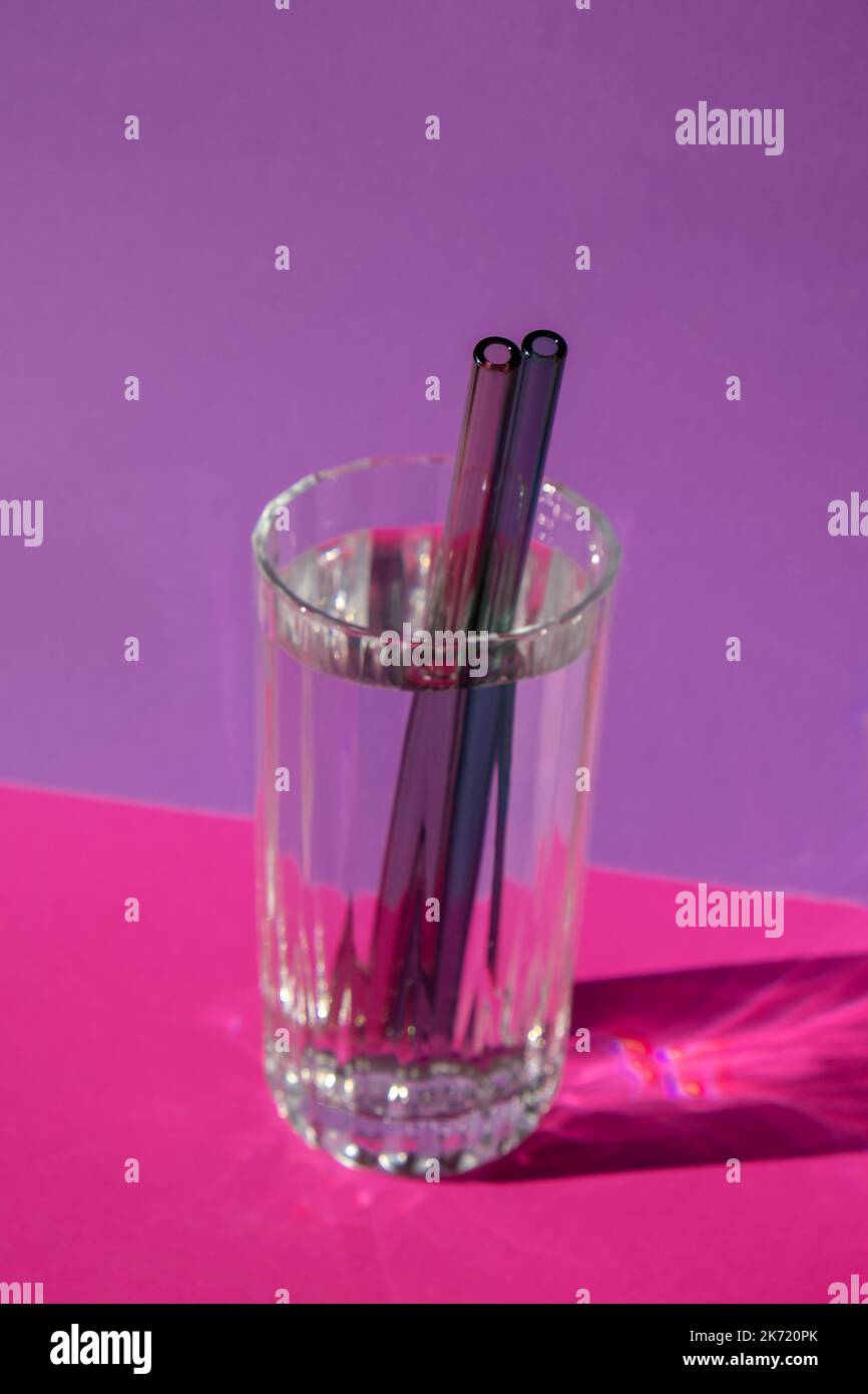 Reusable glass Straws in Glass with water on purple violet background ...