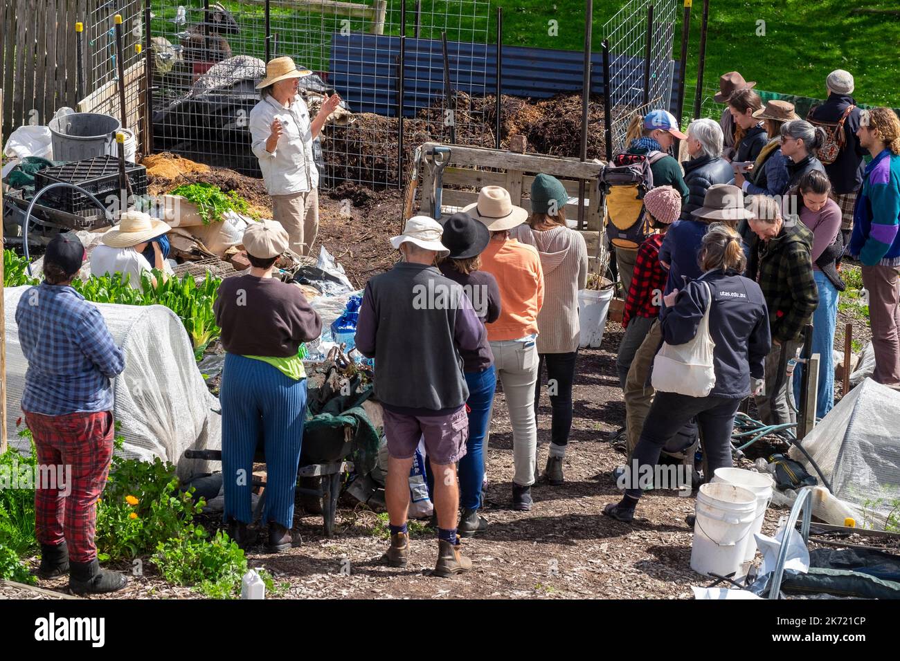 A group of permaculture students attending a composting workshop on a ...