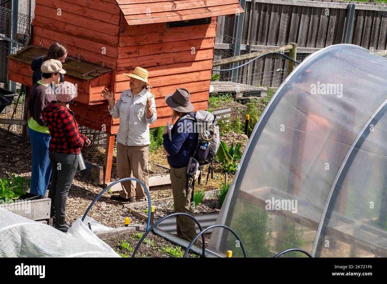 A group of permaculture students attending a composting workshop on a ...