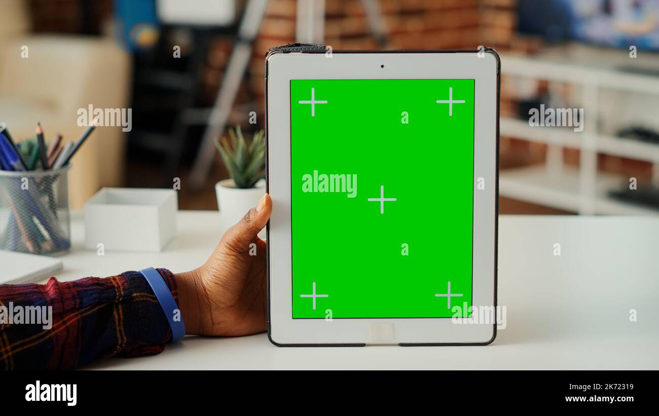 Young woman vertically holding device with green screen, analyzing ...