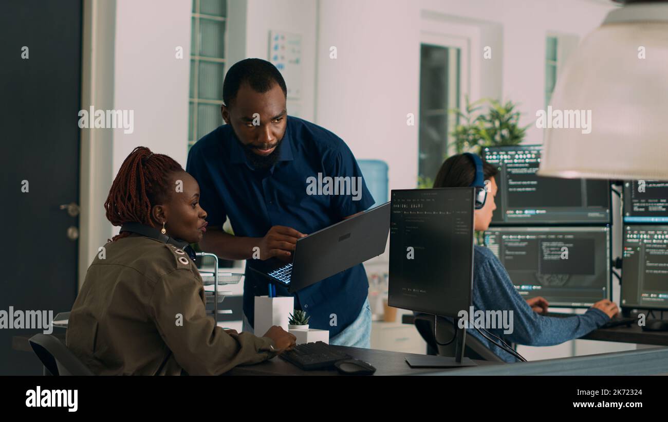 Team Of Software Developers Talking About Source Code Running On Laptop To Work On Artificial