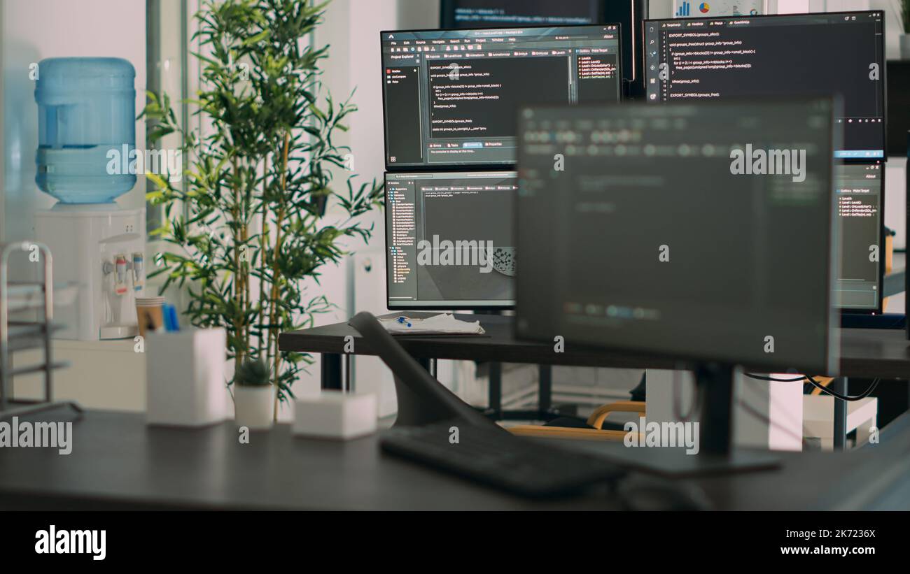 Empty Desk With Multiple Monitors Displaying Server Code And Programming Language Compiling In