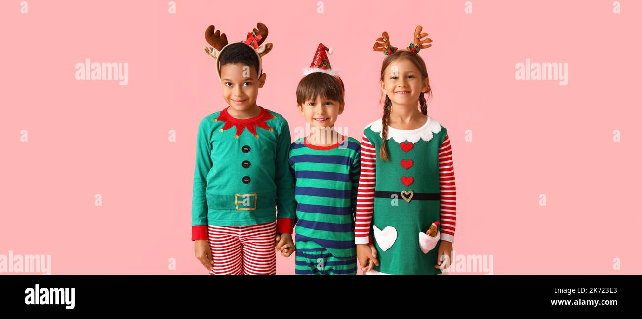 Cute little children dressed as elves on pink background Stock Photo ...